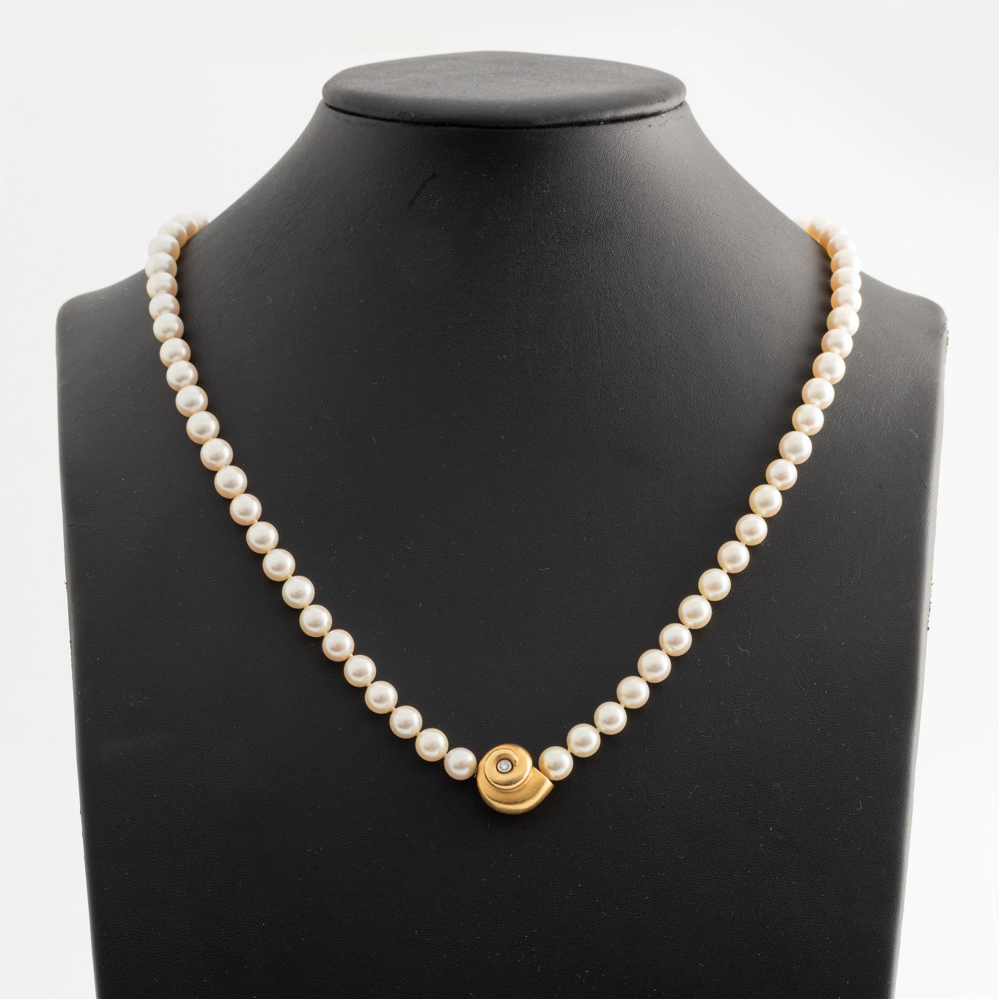 An 18K gold Ole Lynggaard clasp set with a round brilliant--cut diamond ...