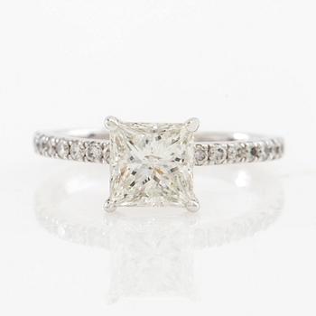 Ring 18K vitguld med en prinsesslipad diamant samt runda ...