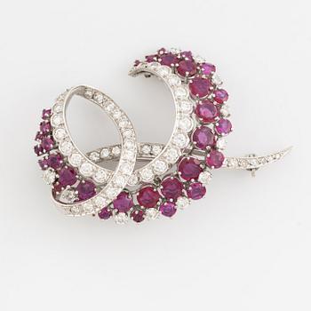 An 18K white gold brooch set with faceted rubies and round brilliant- and eight-cut diamonds ...