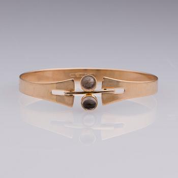 ARMRING, cabochonslipad rökkvarts, 14K guld. Holger Lindström, Helsingfors 1967. - Bukowskis