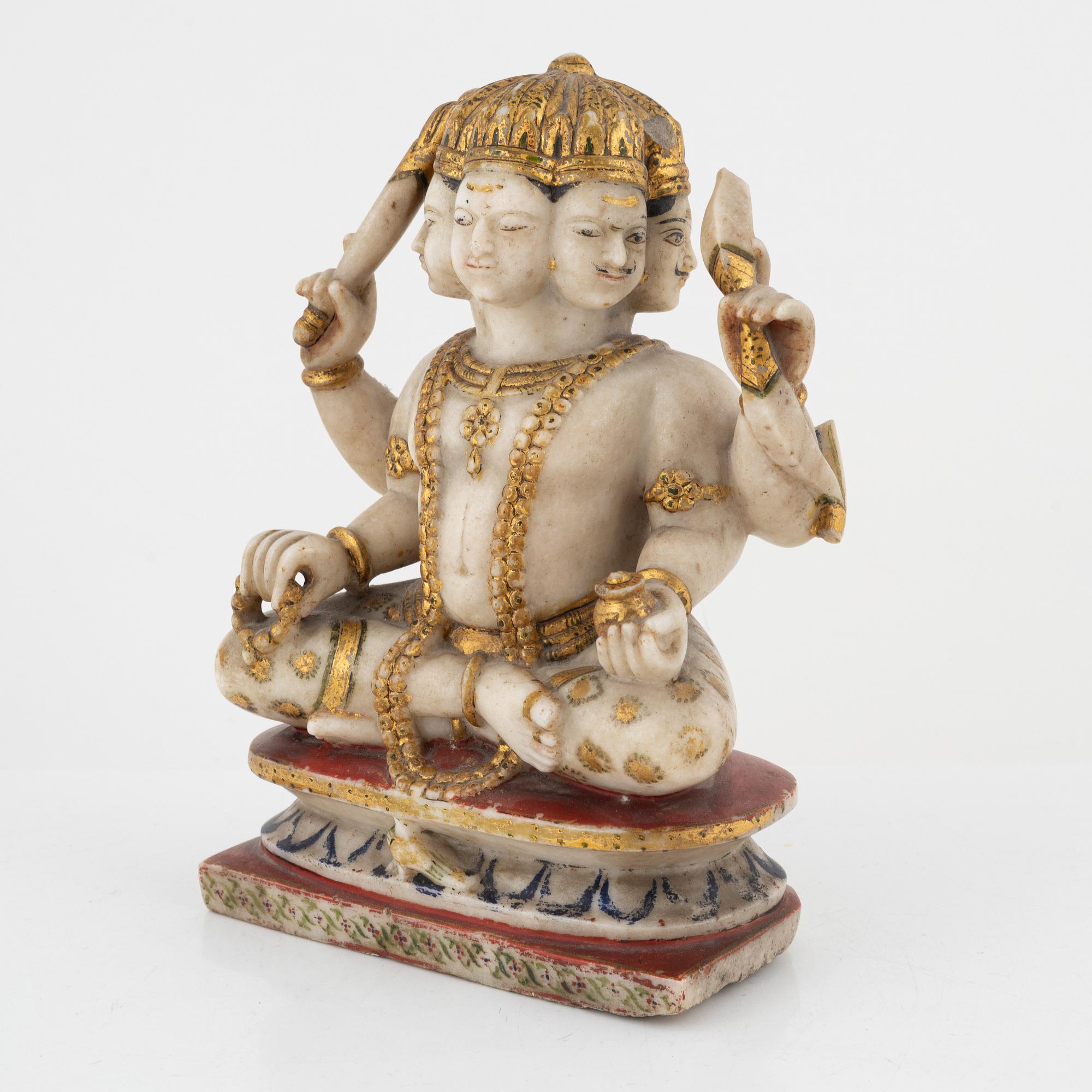An alabaster sculpture of an deity with six heads and four arms, India ...